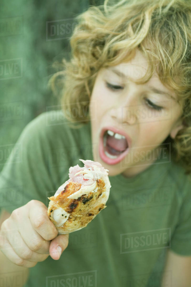 Boy ready to take a bite out of grilled chicken leg - Stock Photo ...
