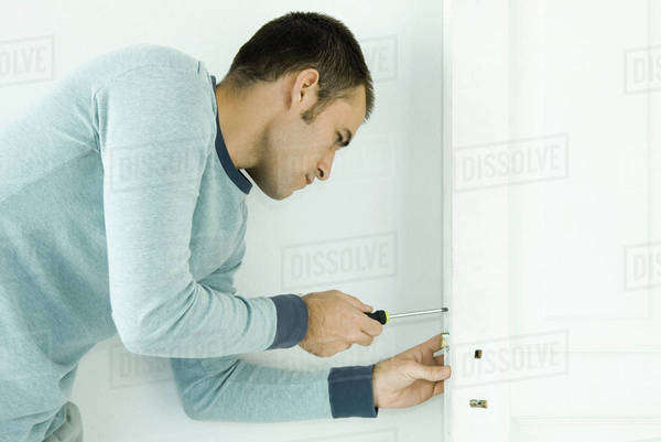 Man removing lock from door - Royalty-free Stock Photo | Dissolve