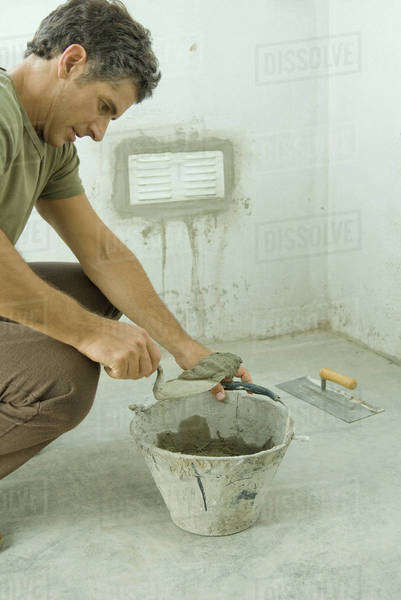 Man applying plaster around air vent - Royalty-free Stock Photo | Dissolve