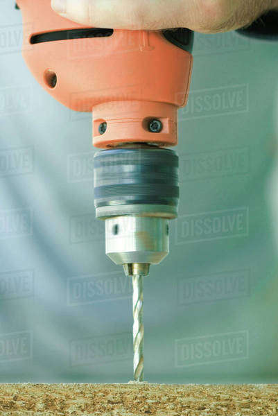 Man using drill, close-up - Stock Photo - Dissolve