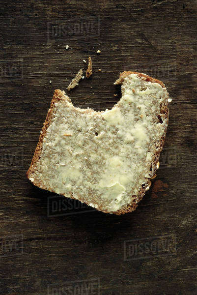 Buttered bread with bite missing - Royalty-free Stock Photo | Dissolve