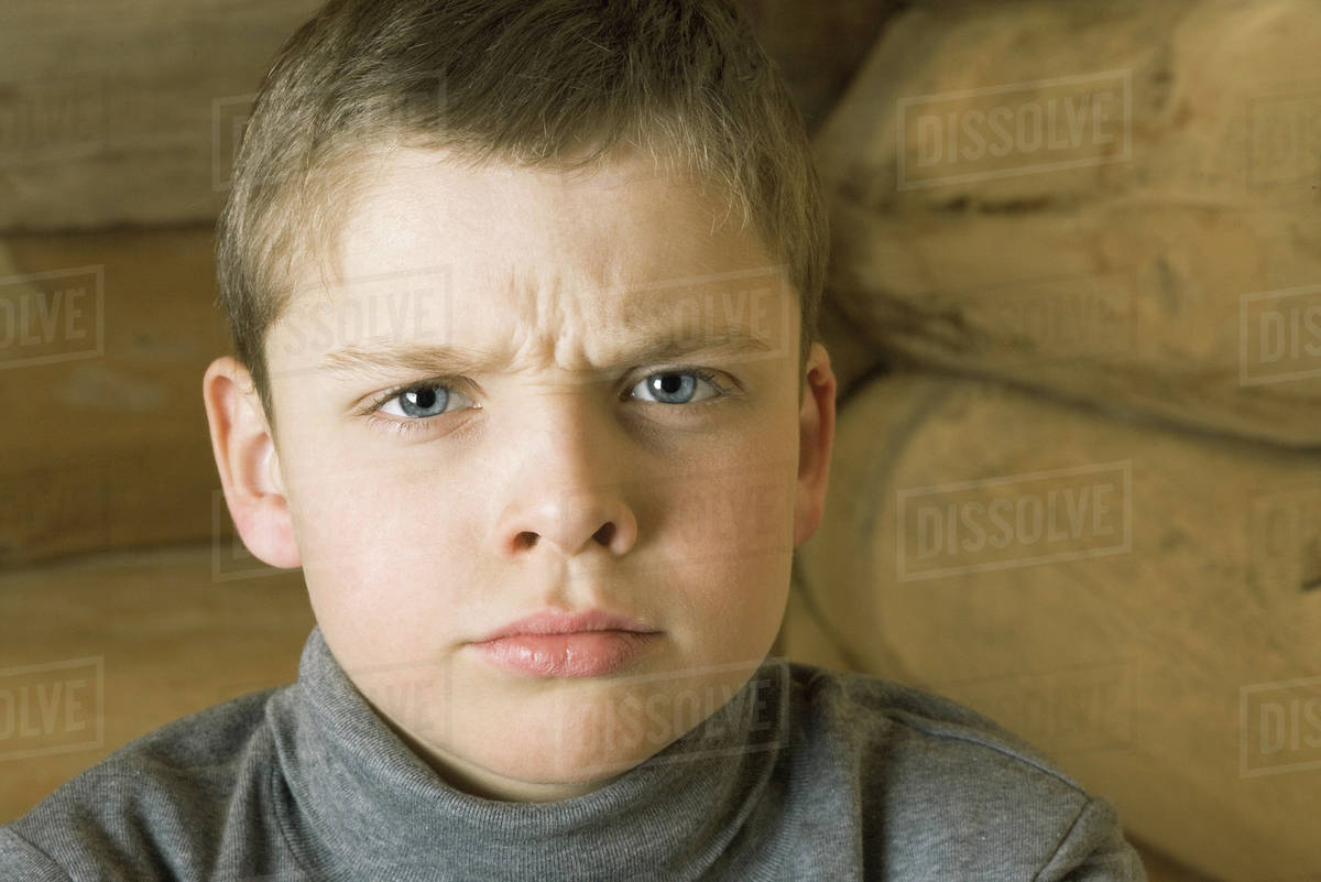 Boy frowning at camera, portrait - Royalty-free Stock Photo | Dissolve