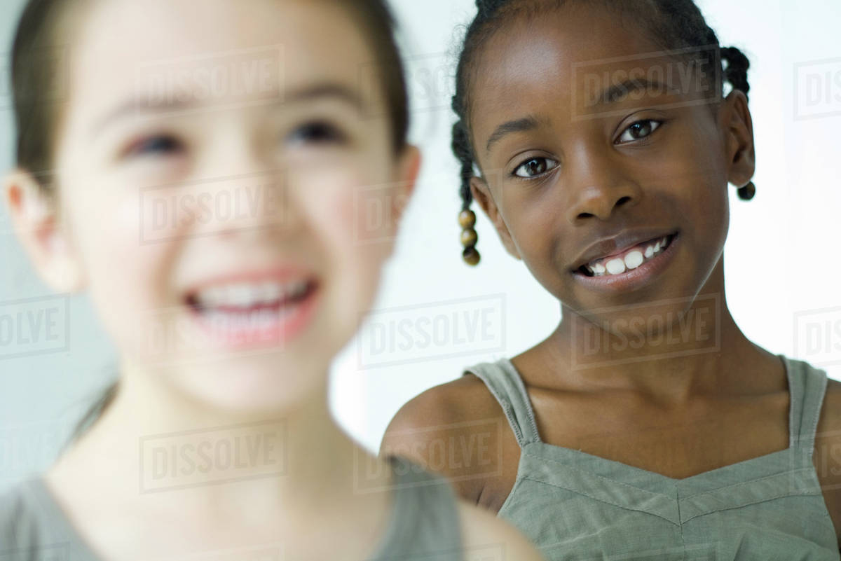 Two girls smiling, one looking at camera, selective focus - Royalty ...