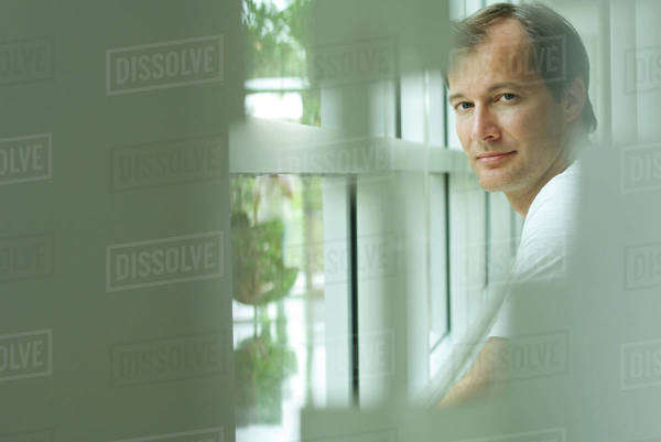 Man by window, looking at camera, selective focus - Royalty-free Stock ...