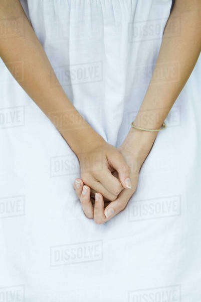 Teenage girl with clasped hands, cropped view - Stock Photo - Dissolve