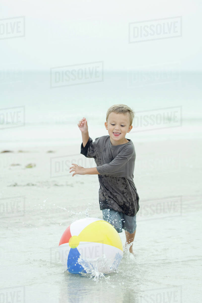 Little boy chasing beach ball at the beach, full length - Stock Photo ...