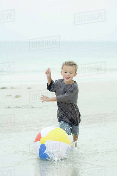 Little boy chasing beach ball at the beach, full length - Stock Photo ...