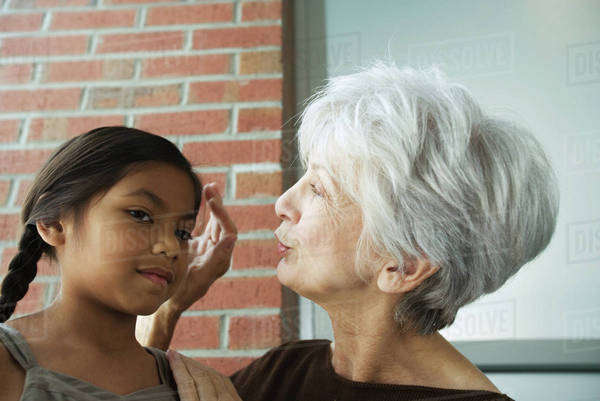 Grandmother touching granddaughter's head, close-up - Stock Photo ...