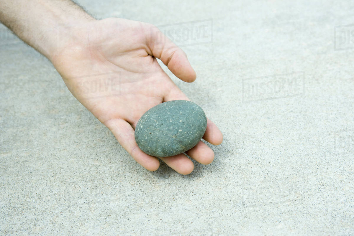 Man holding pebble in hand, cropped view - Royalty-free Stock Photo ...
