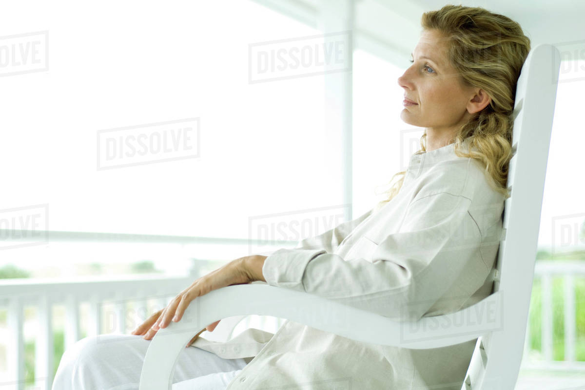 Woman sitting in rocking chair on porch, side view - Royalty-free Stock ...