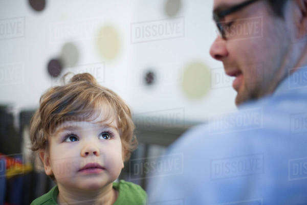 Toddler boy looking attentively at father - Stock Photo - Dissolve