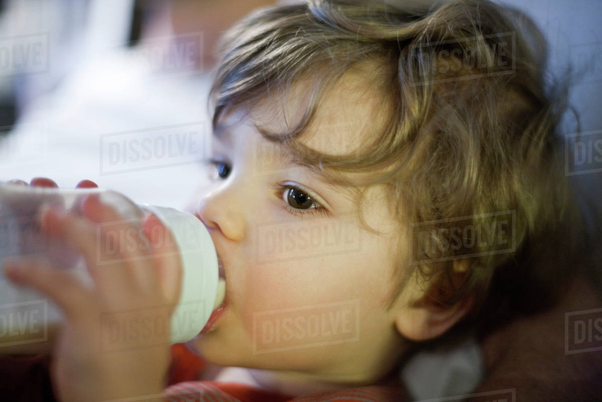 Toddler Boy Drinking Milk From Baby Bottle Stock Photo Dissolve