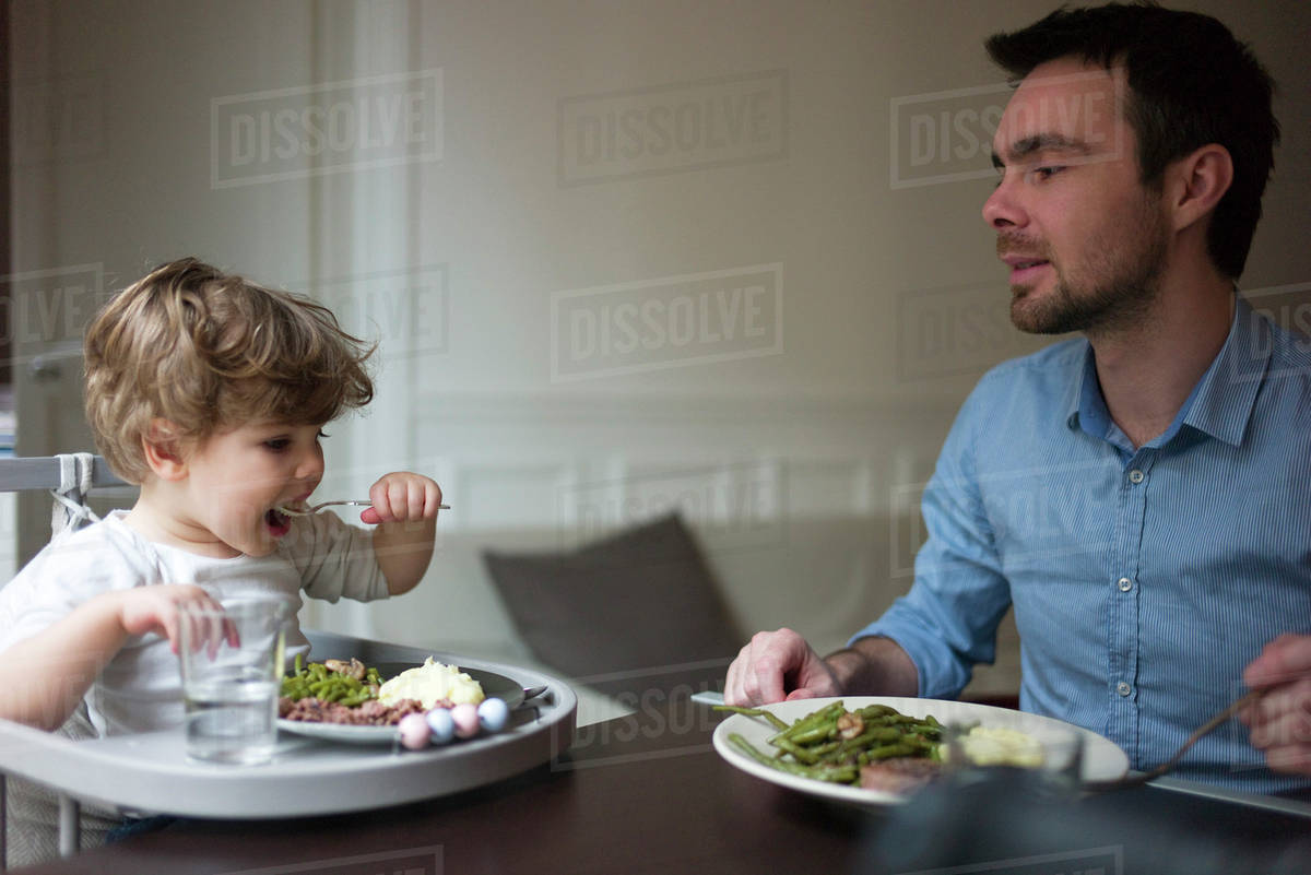 Father and toddler son eating dinner together - Royalty-free Stock ...