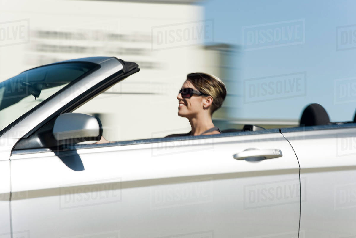 Woman driving fast in convertible - Royalty-free Stock Photo | Dissolve