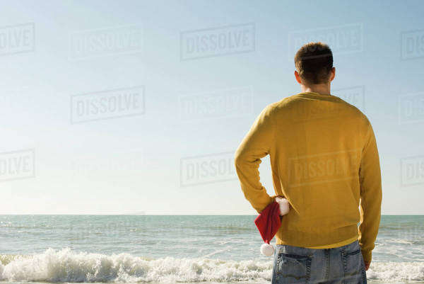 Young man at beach looking at view - Royalty-free Stock Photo | Dissolve