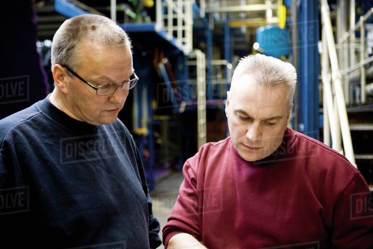 Textile workers having a discussion in factory - Royalty-free Stock ...