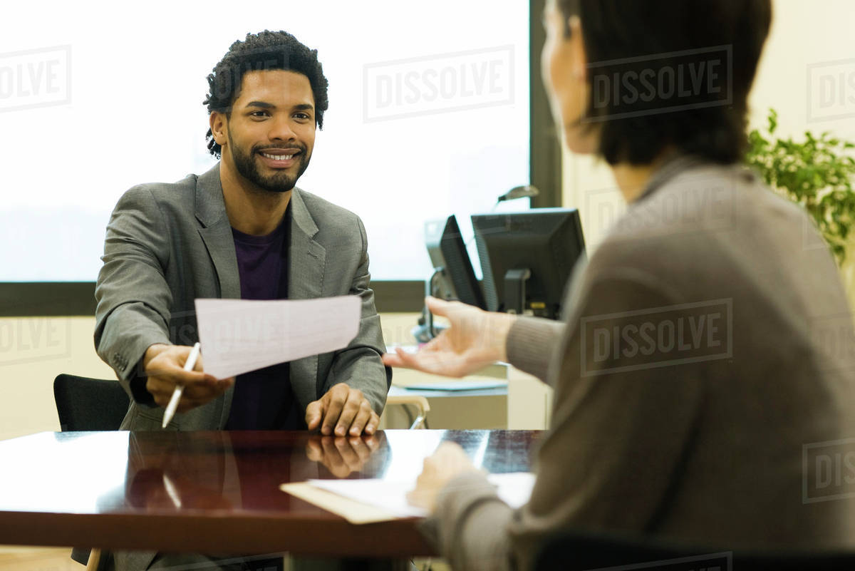 Executive handing document to colleague - Royalty-free Stock Photo ...