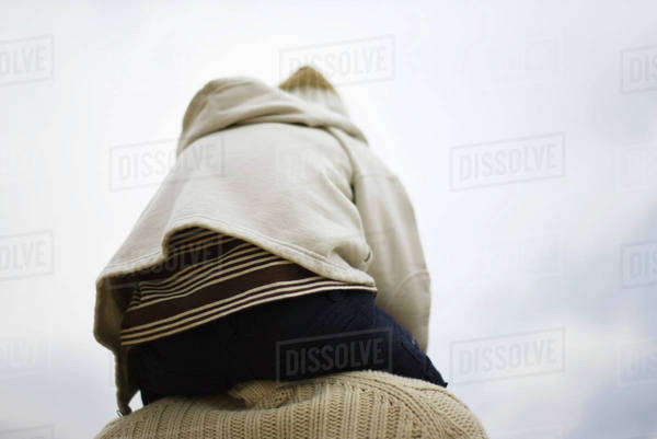 Child sitting on parent's shoulders, rear view - Royalty-free Stock ...
