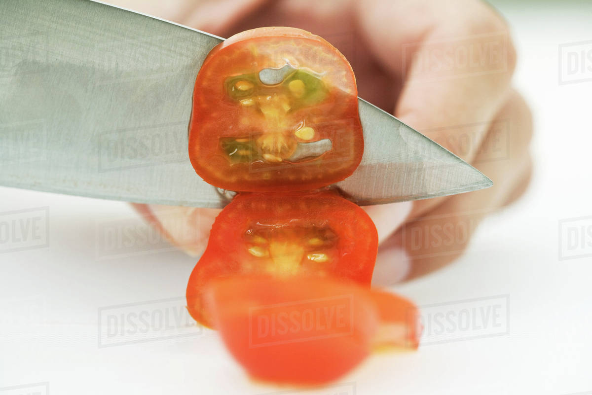 Woman slicing tomato with knife, cropped view of hand - Stock Photo ...