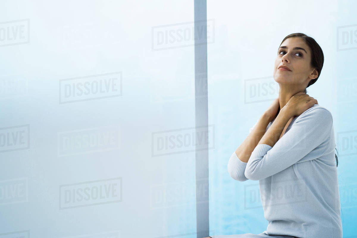 Woman with hands behind neck, looking up - Royalty-free Stock Photo ...