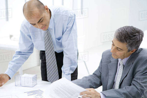 Two businessmen looking over documents together - Stock Photo - Dissolve