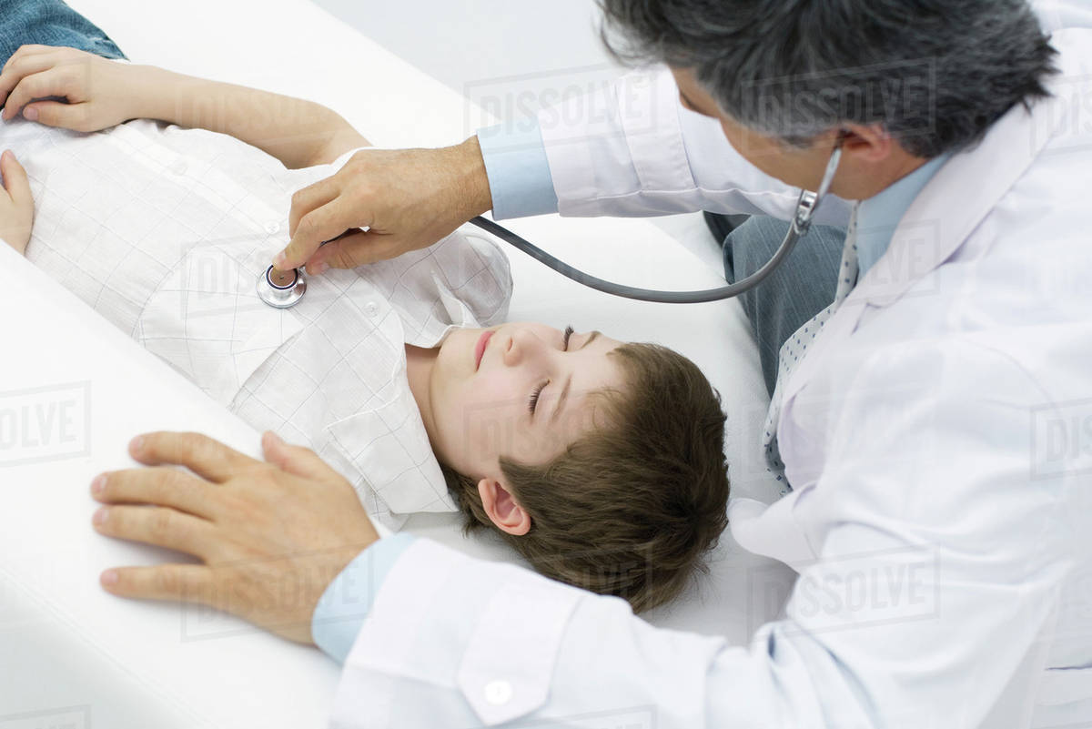 Doctor listening to young patient's heart, high angle view - Royalty ...