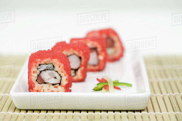 Maki sushi rolled in red flying fish roe, cross section view - Royalty ...