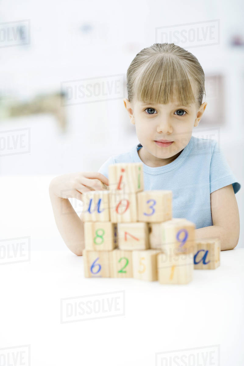 Little girl stacking blocks, looking at camera, portrait - Royalty-free ...