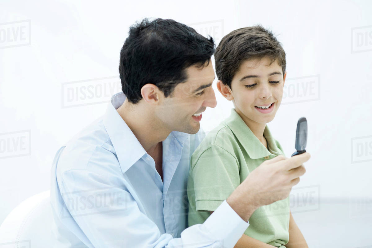 Father and son looking at cell phone together - Royalty-free Stock ...