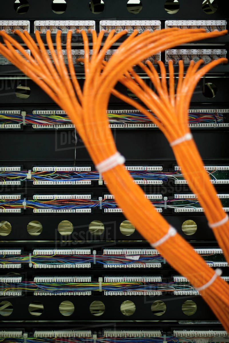 Network cables connected to computer mainframe - Stock Photo - Dissolve