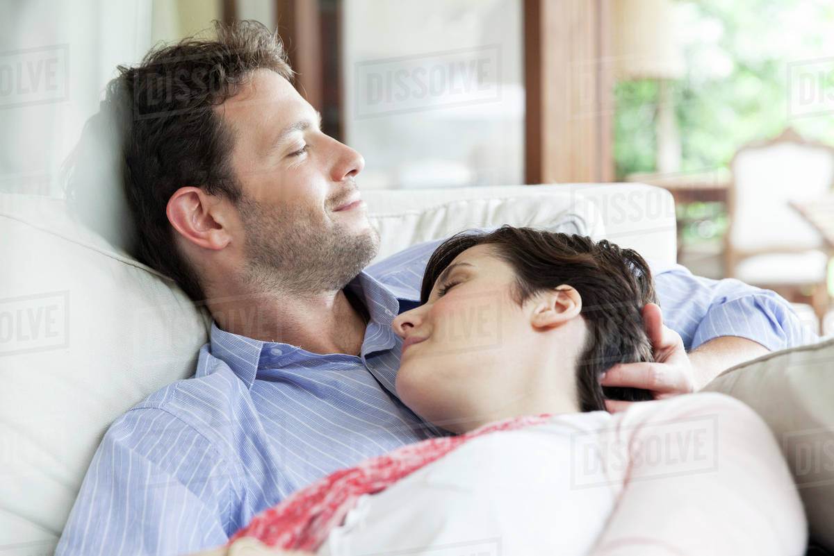 Couple napping together on sofa - Royalty-free Stock Photo | Dissolve