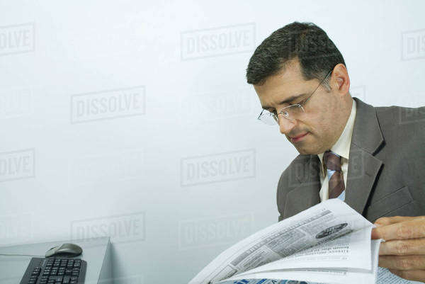 Businessman looking at newspaper - Royalty-free Stock Photo | Dissolve