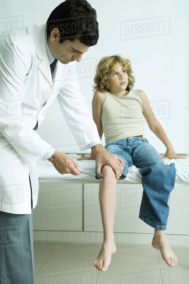 Doctor checking boy's reflexes - Royalty-free Stock Photo | Dissolve