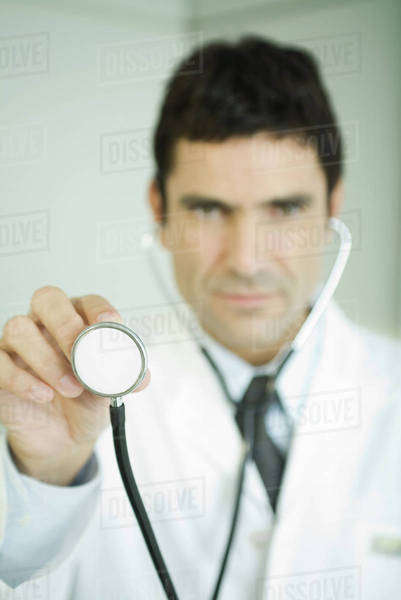 Doctor holding up stethoscope, looking at camera - Royalty-free Stock ...