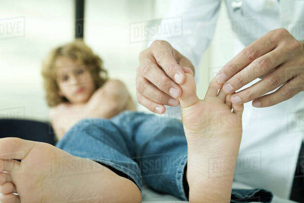 Doctor examining boy's toes - Royalty-free Stock Photo | Dissolve