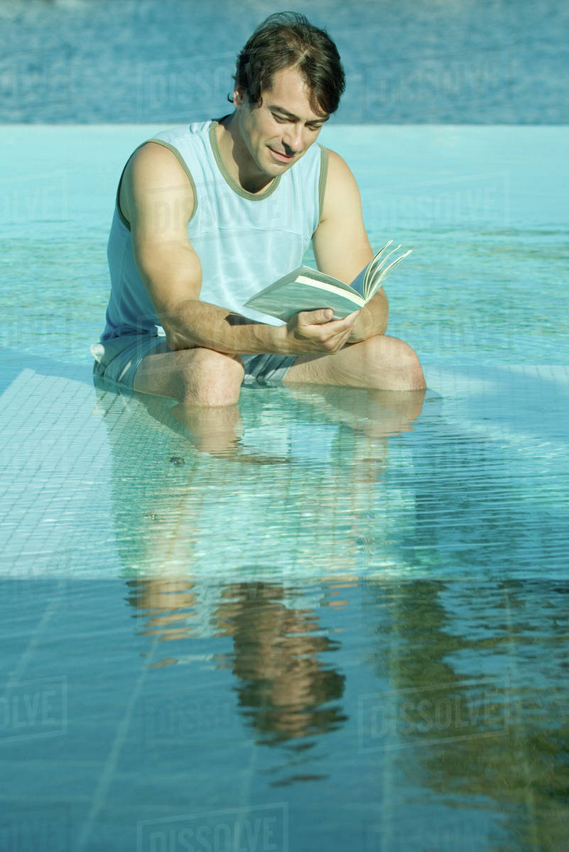 Man sitting in pool, reading - Royalty-free Stock Photo | Dissolve