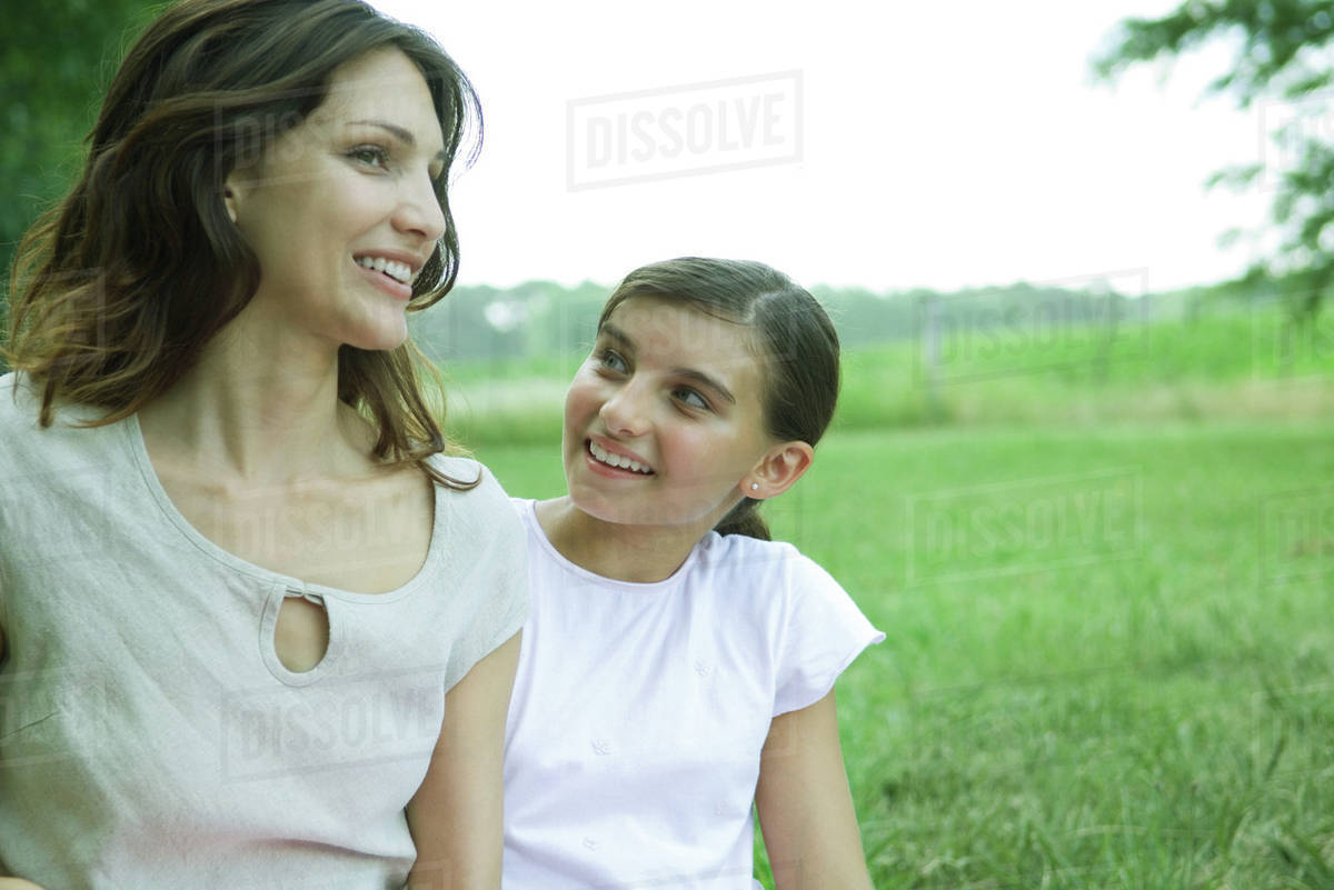 Girl looking up at mother, smiling - Royalty-free Stock Photo | Dissolve