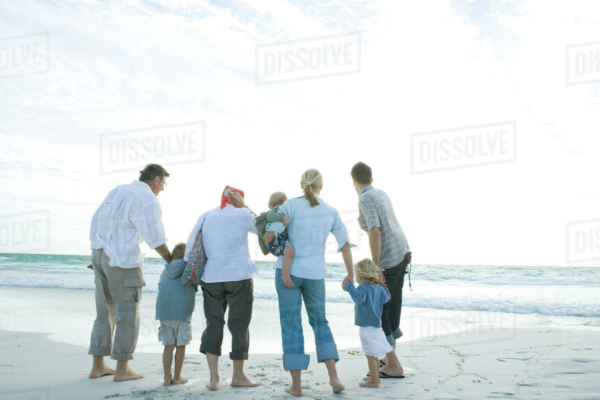 Three generation family standing on beach - Stock Photo - Dissolve