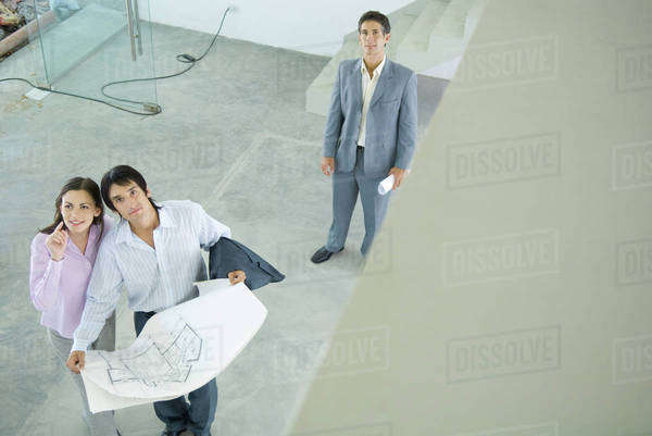 Male real estate agent standing in home interior with young couple ...