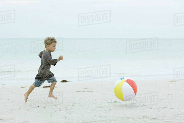 Little boy running after ball on beach - Royalty-free Stock Photo ...