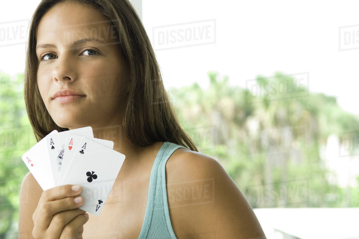 Teenage girl showing cards, smiling at camera - Stock Photo - Dissolve