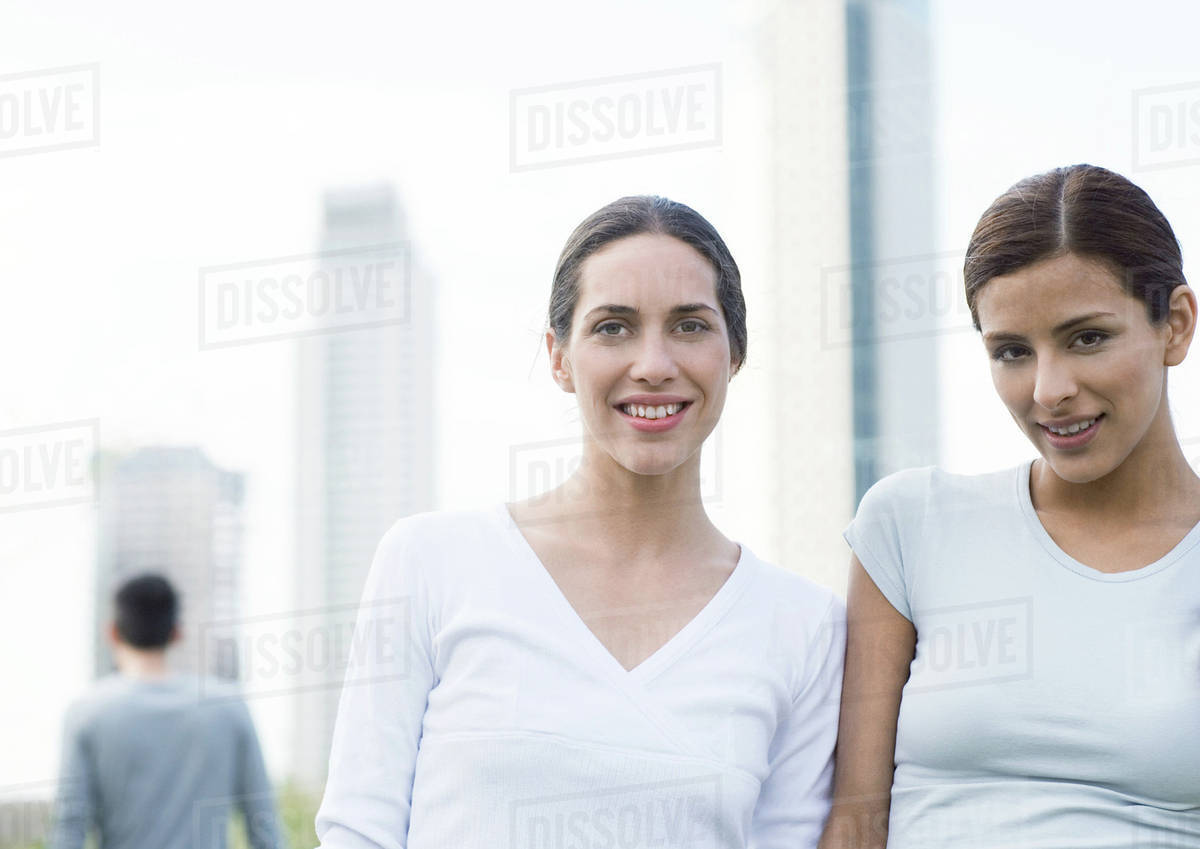 Two young woman, side by side in urban setting - Stock Photo - Dissolve