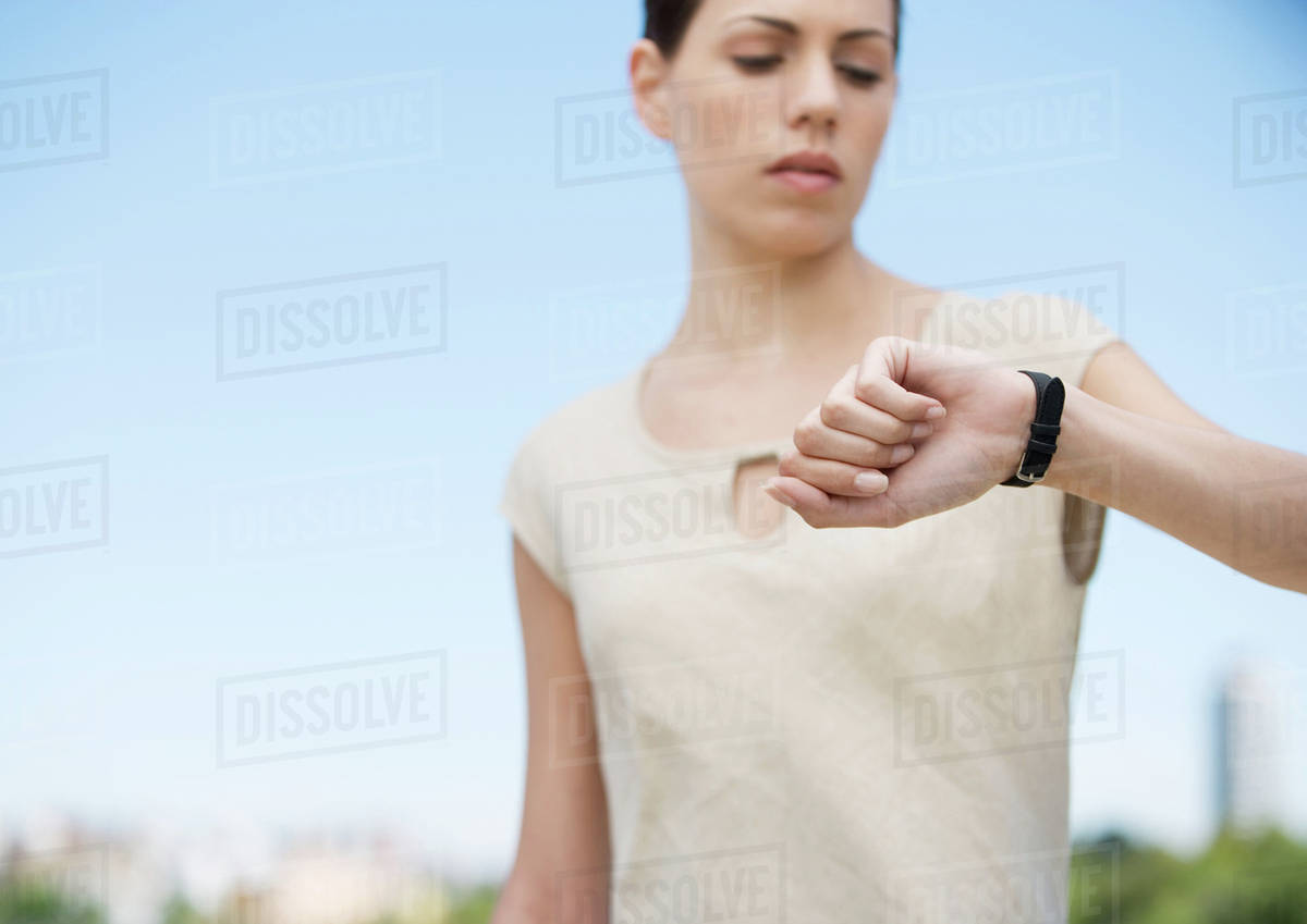 Young woman checking watch - Royalty-free Stock Photo | Dissolve
