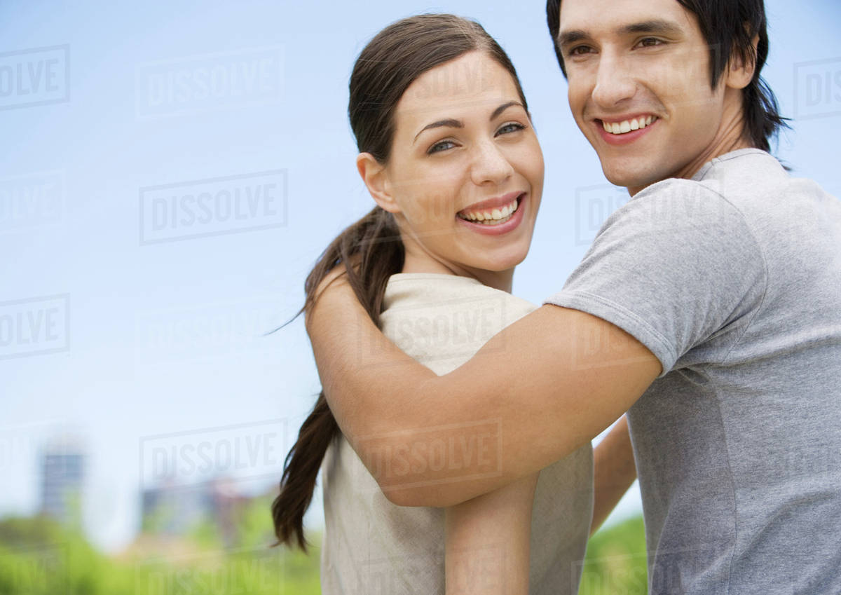 Young couple looking over shoulders, smiling - Royalty-free Stock Photo ...