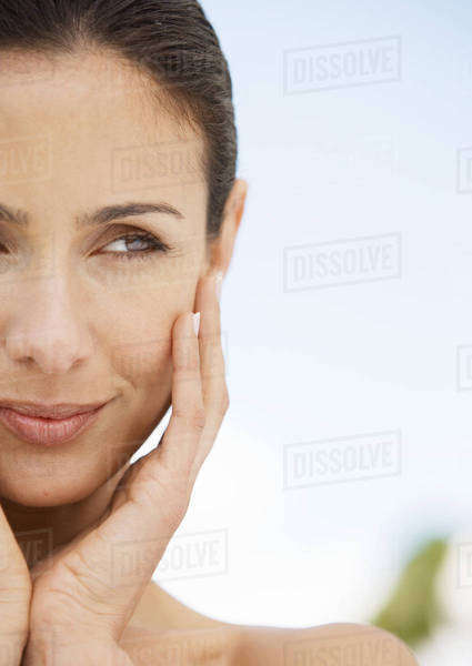 Woman holding face in hands, portrait - Royalty-free Stock Photo | Dissolve