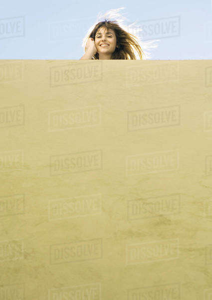 Young woman looking over wall, low angle view - Royalty-free Stock ...