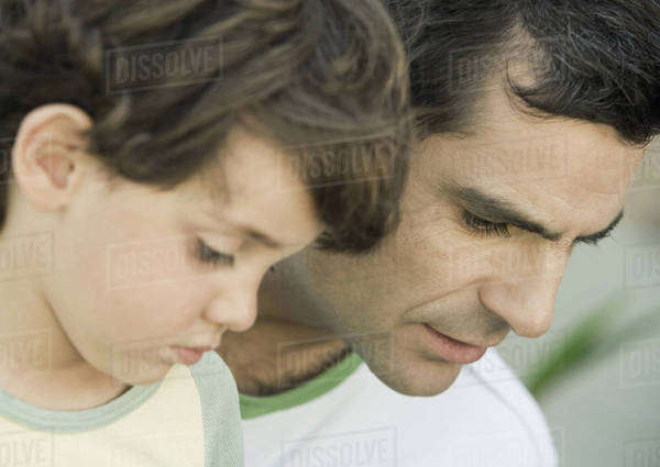 Father and son side by side and looking down together, side view ...