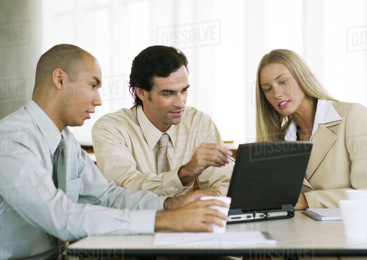 Three young executives working at laptop together - Royalty-free Stock ...