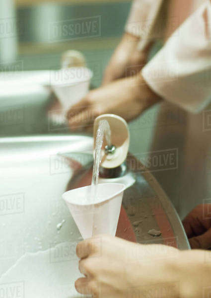 Filling cups at water fountain - Stock Photo - Dissolve
