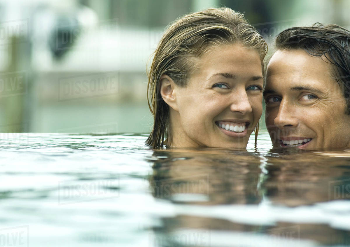 Couple smiling in pool - Royalty-free Stock Photo | Dissolve